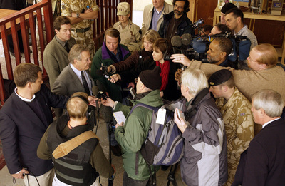 Reporters surround Secretary Rumsfeld as he answers a question during ...
