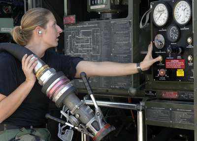 Senior Airman Amy Finkbeiner rewinds a fuel hose. | U.S. Department of War