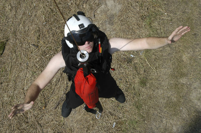 A Navy Search and Rescue swimmer is hoisted back on board a MH-60S ...