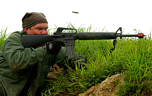 A member of the opposing forces fires his M16 rifle at U.S. Air Force ...
