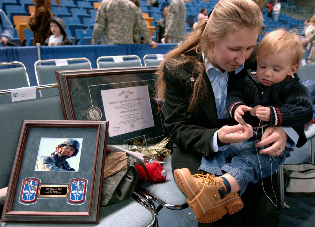 Family members of Staff Sgt. Mark A. Wall look at his dog tags after ...