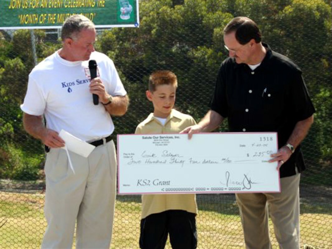 Eric Salazar, 11, of California, receives a grant check from ...