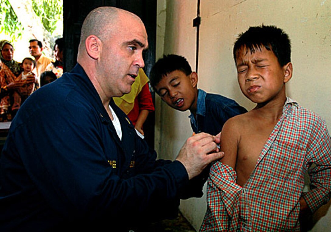 U.S. Navy Chief Hospital Corpsman Thomas Twigg administers an ...