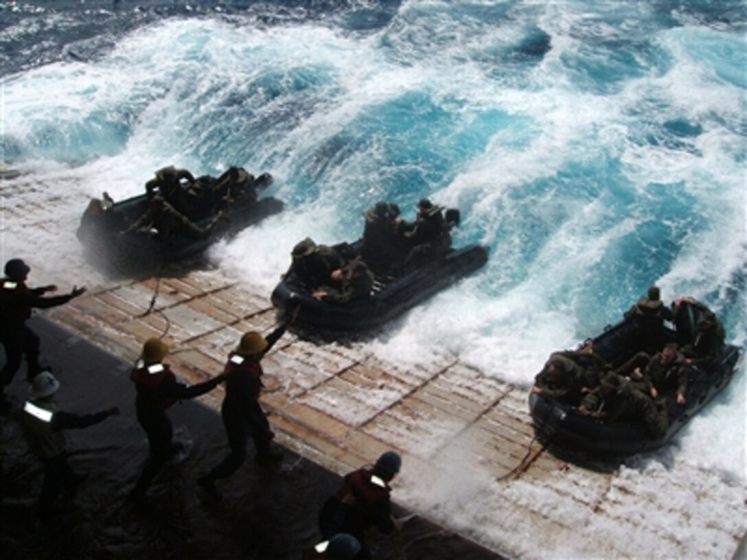 U.S. Navy sailors in combat rubber raiding craft are recovered.