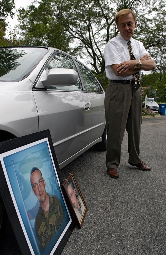 Noel Totten looks down on a portrait and a photo of his brother, Chief ...