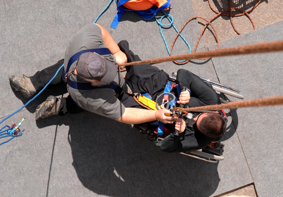 U.S. Army Cpl. Shane Parsons ties a rope with assistance from his ...