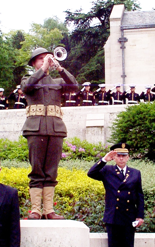 Marines salute as a bugler decked in a World War I uniform plays Taps ...