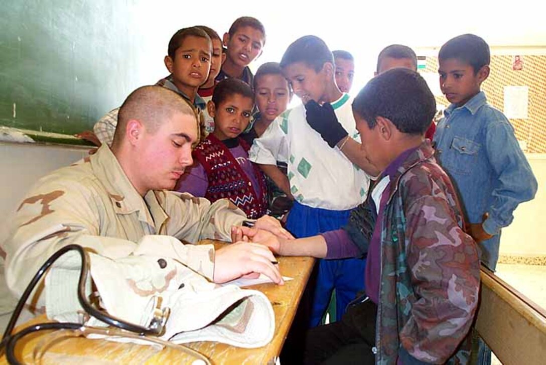 Seaman Apprentice Timothy Hoyt checks a Jordanian child’s pulse while ...