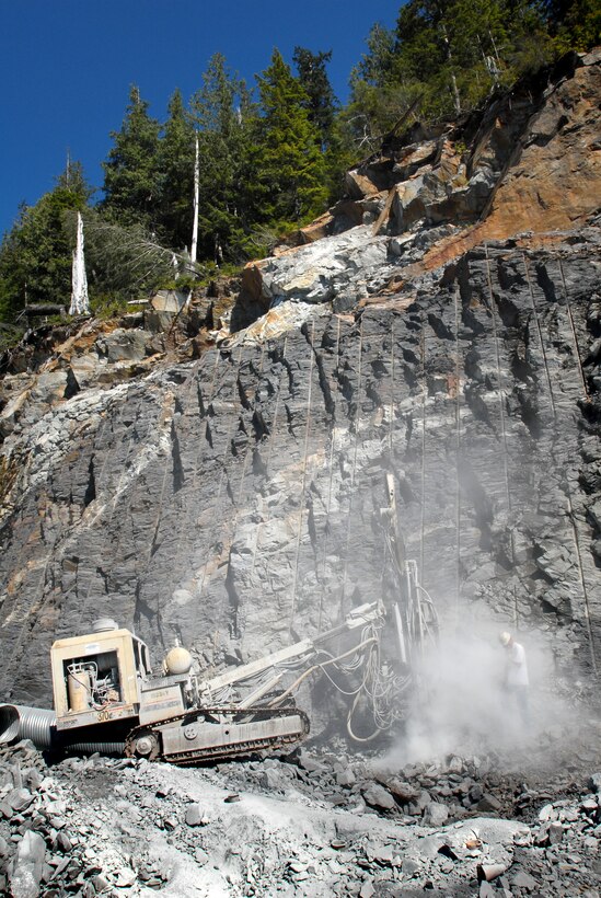 A crew drills to blast a final section of the Walden Point Road on ...