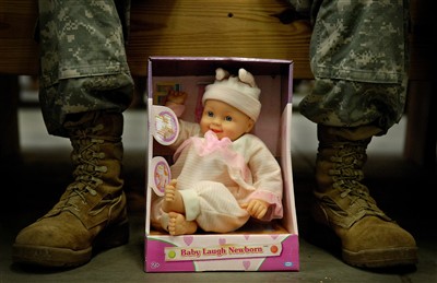A baby doll sits at the feet of U.S. Army Sgt. Patrick Fuhrman.