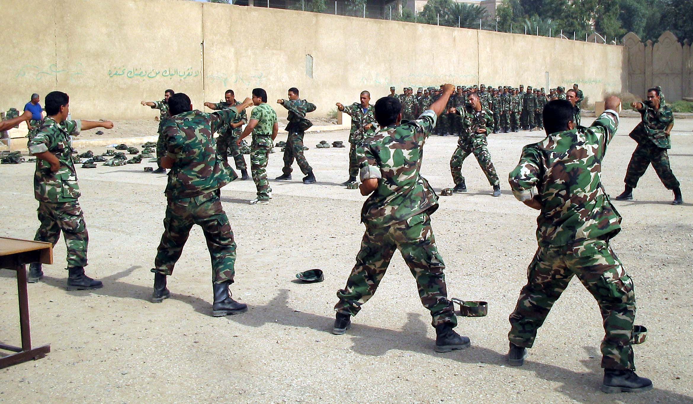 Iraqi police commando recruits perform martial arts drills during their ...