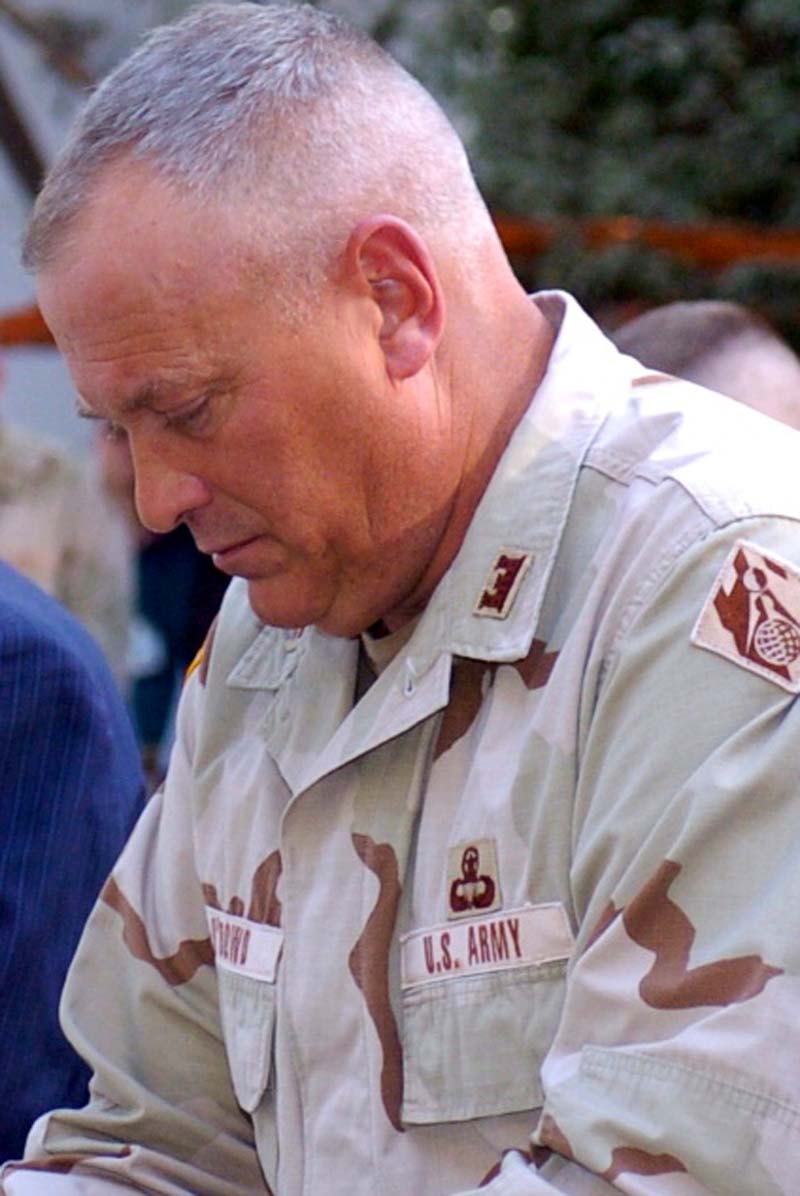 Army Col. John O'Dowd bows his head in solemn remembrance during a ...