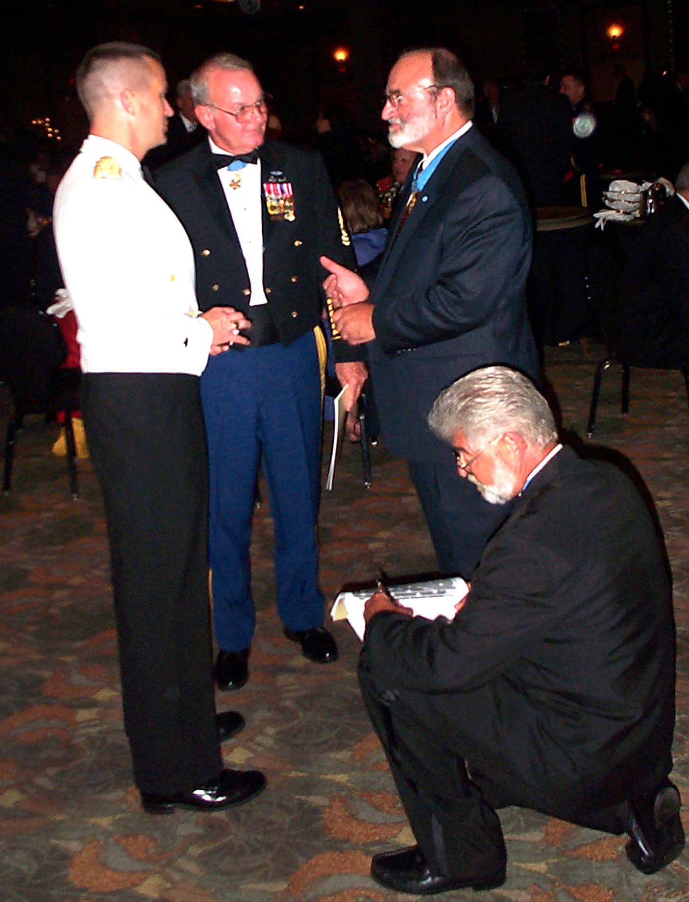 Medal of Honor recipient retired Army Sgt. Maj. Jon Cavaiani stoops ...