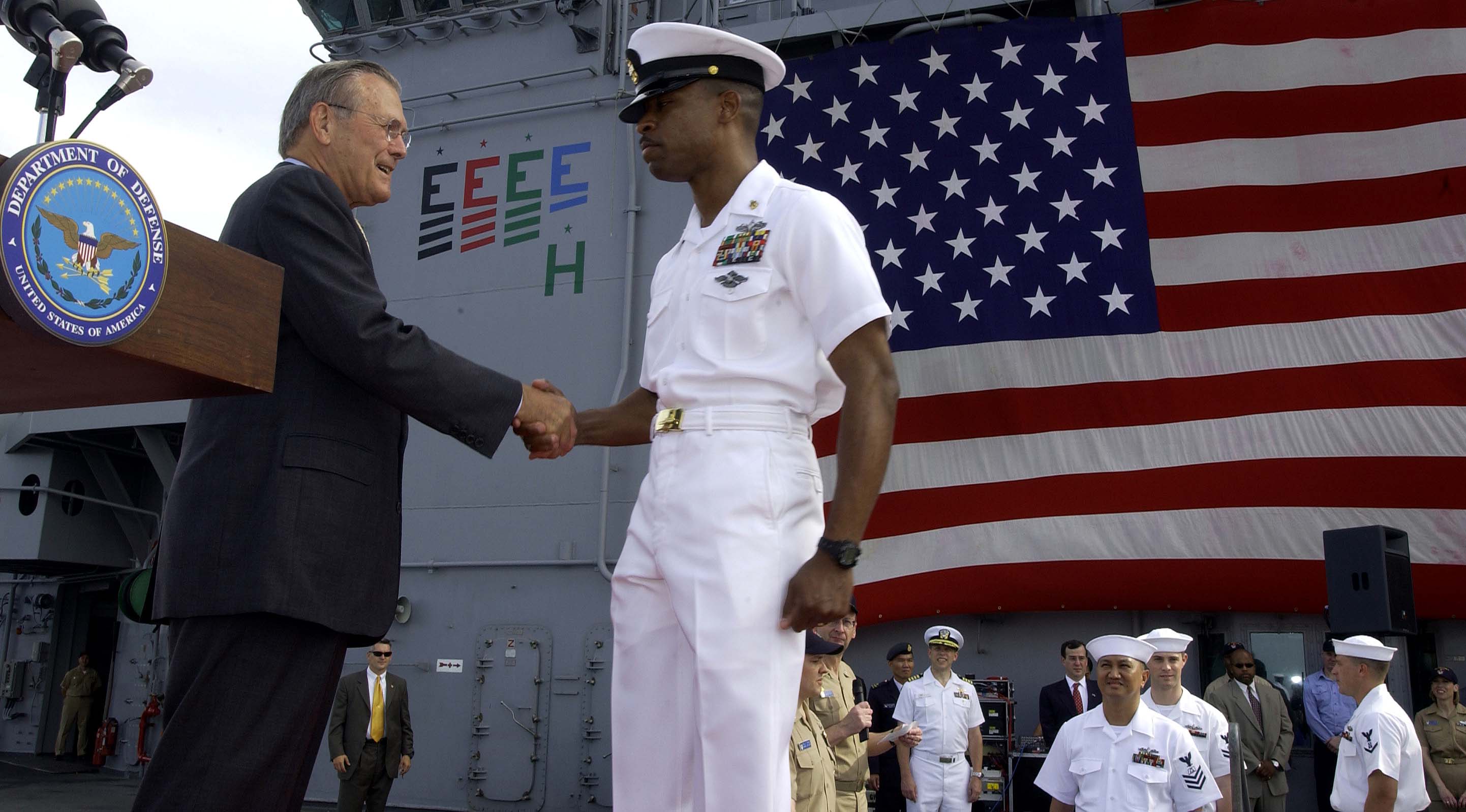 Defense Secretary Donald Rumsfeld congratulates a sailor who has just ...