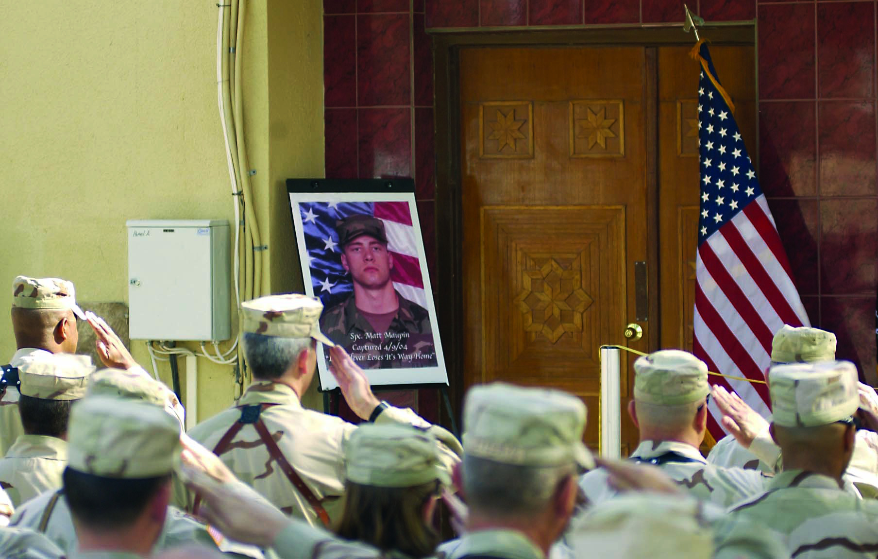 Soldiers salute while the national anthem plays at the dedication ...