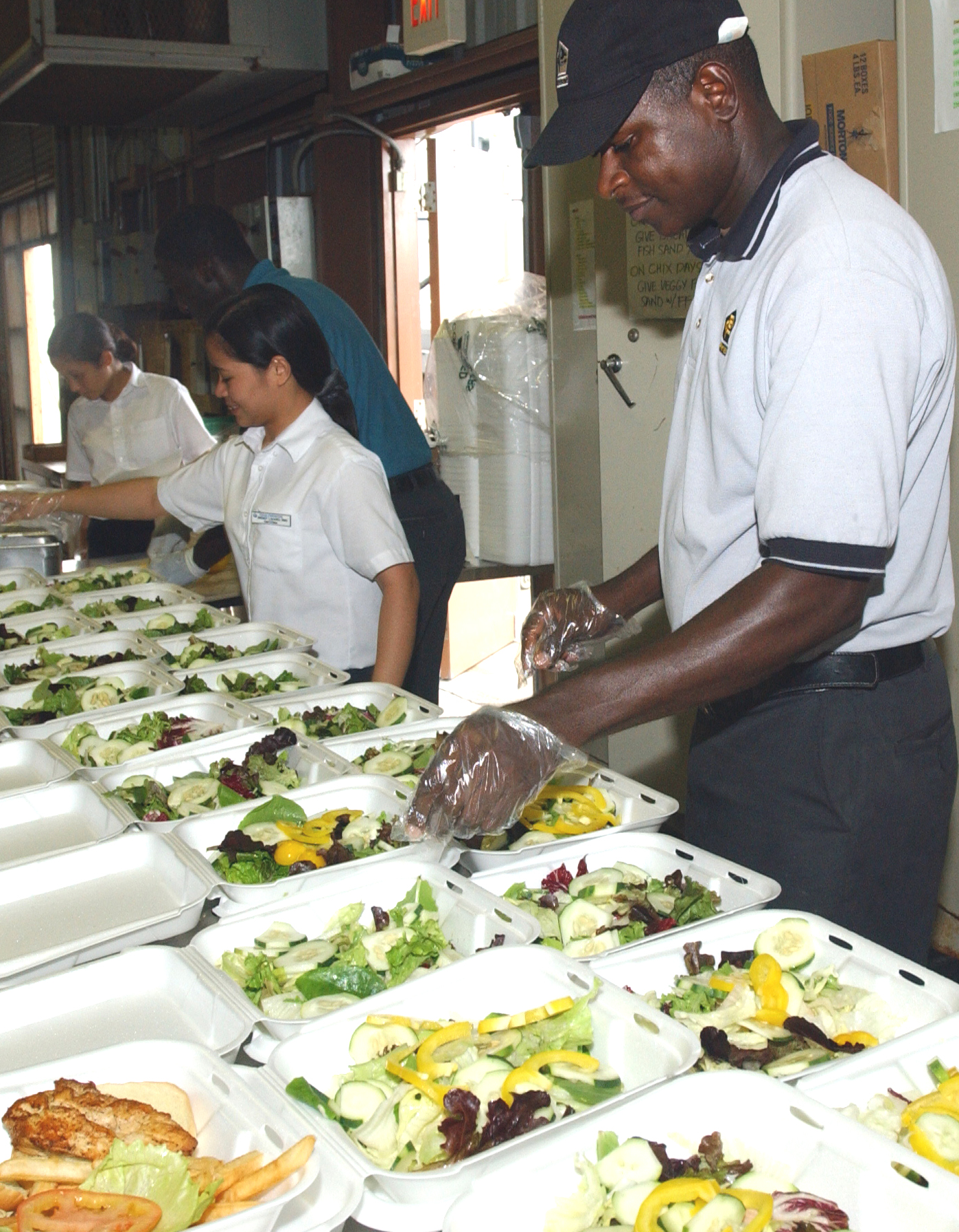 Contracted food service workers prepare meals for detainees at the U.S ...
