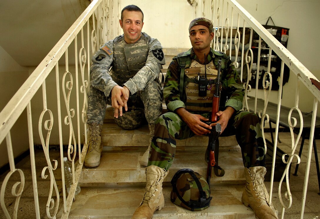A U.S. Army interpreter and an Iraqi army soldier sit side-by-side at ...