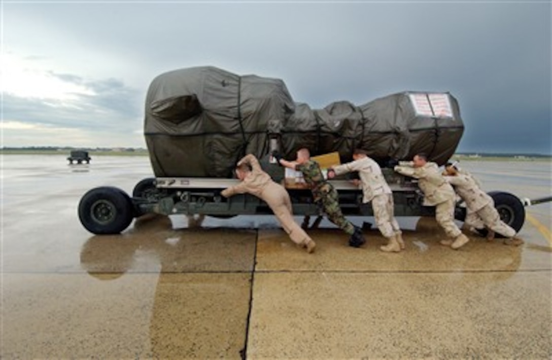 Airmen push a jet engine on a cart. | U.S. Department of War