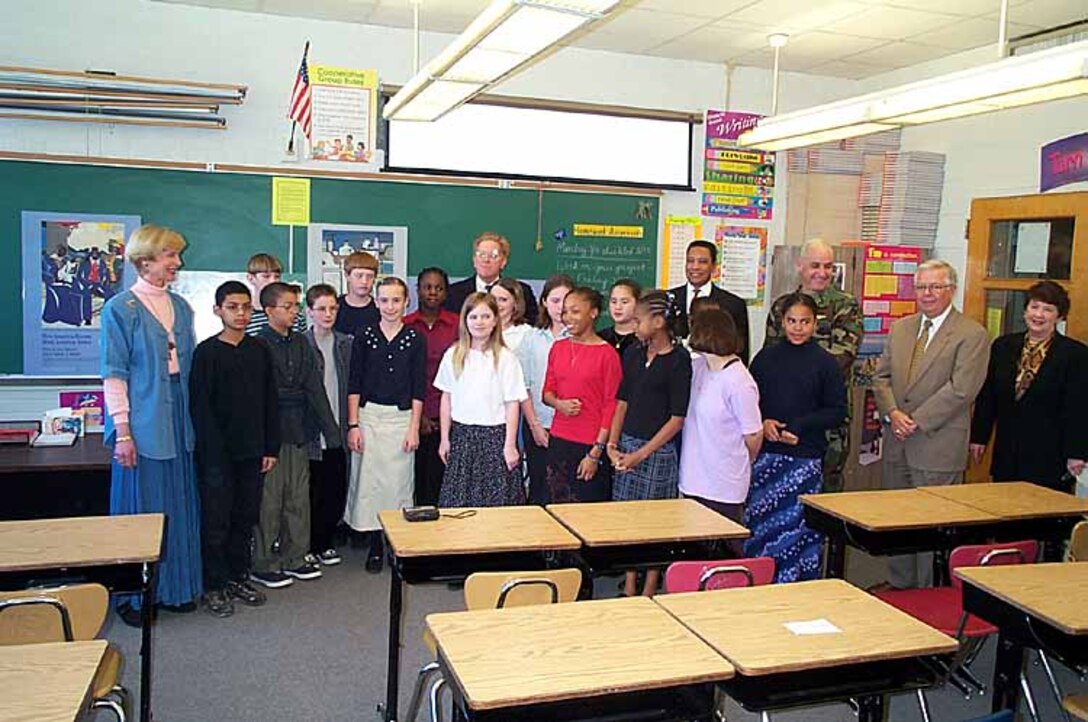 A sixth-grade social studies class poses with Defense Undersecretary ...
