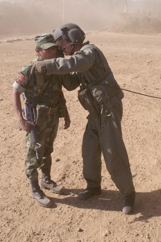 Crew chief Sgt. Robert Harper (right) of Joint Task Force-Bravo tries ...
