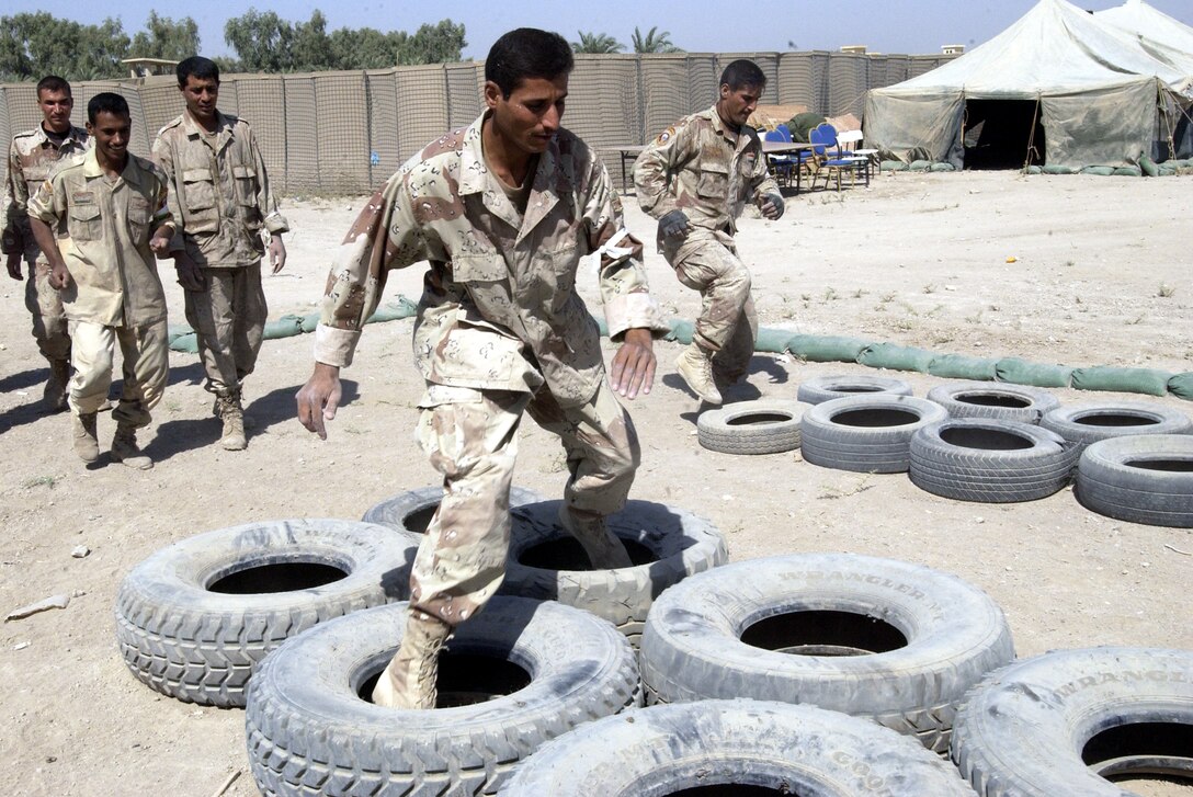 Iraqi army soldiers maneuver through an obstacle course as part of ...