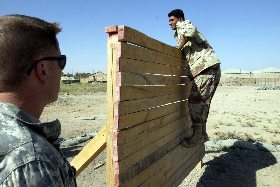 U.S. Army Staff Sgt. Barry Belles observes an Iraqi army soldier ...