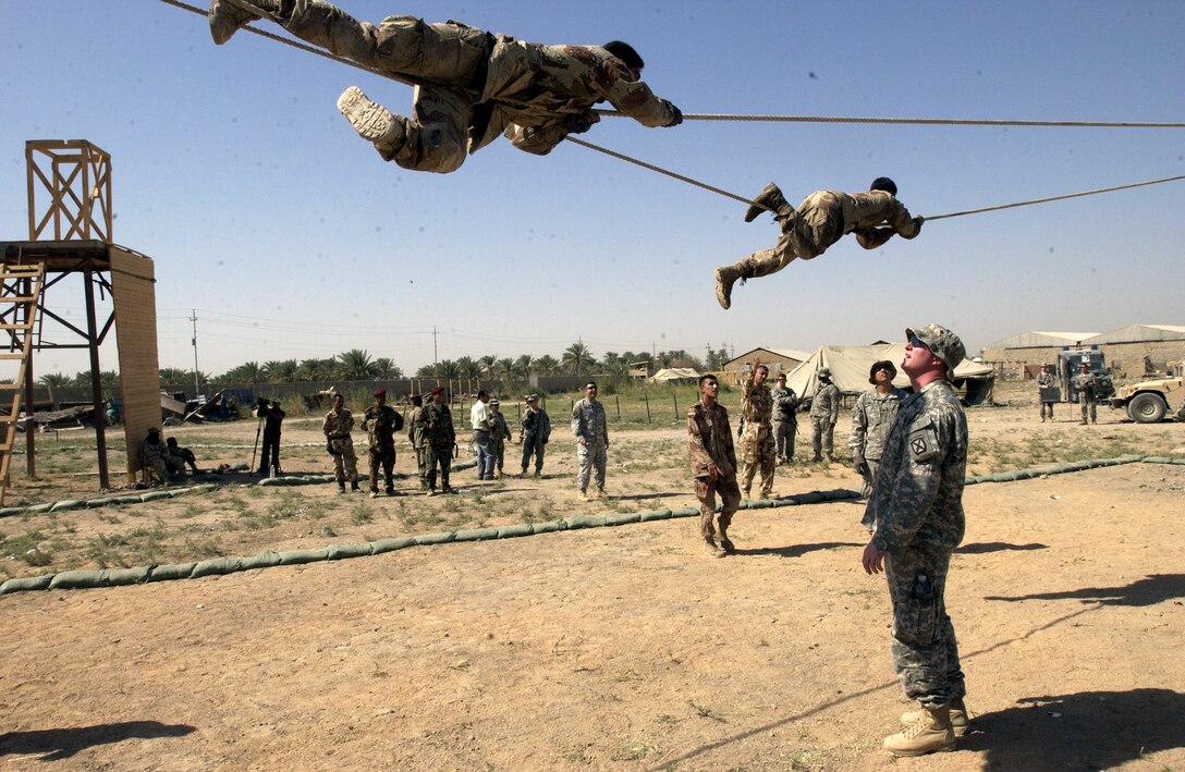 U.S. Army Spc. James Buron watches as Iraqi soldiers maneuver through a ...