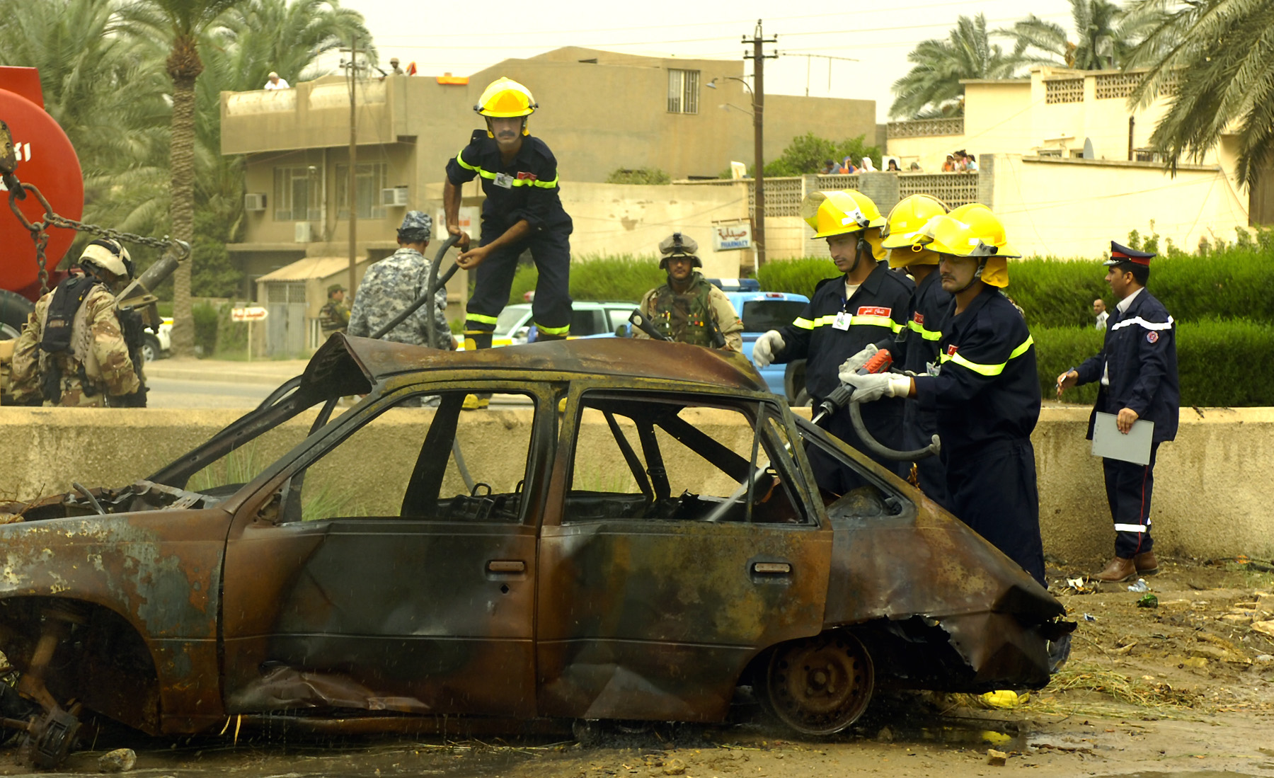 Firefighters with the Yarmouk fire department in Baghdad hose down one ...