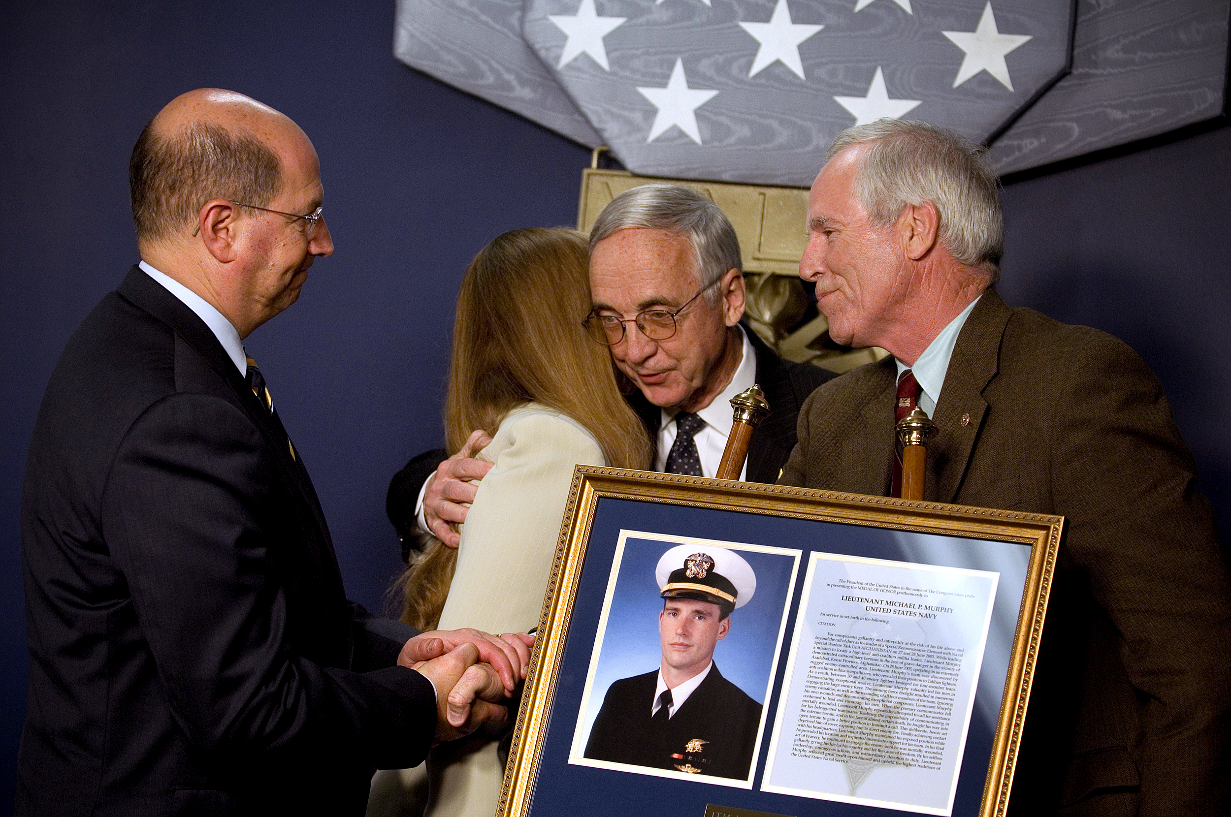 Daniel and Maureen Murphy, the parents of Navy SEAL Lt. Michael Murphy are consoled by Navy ...