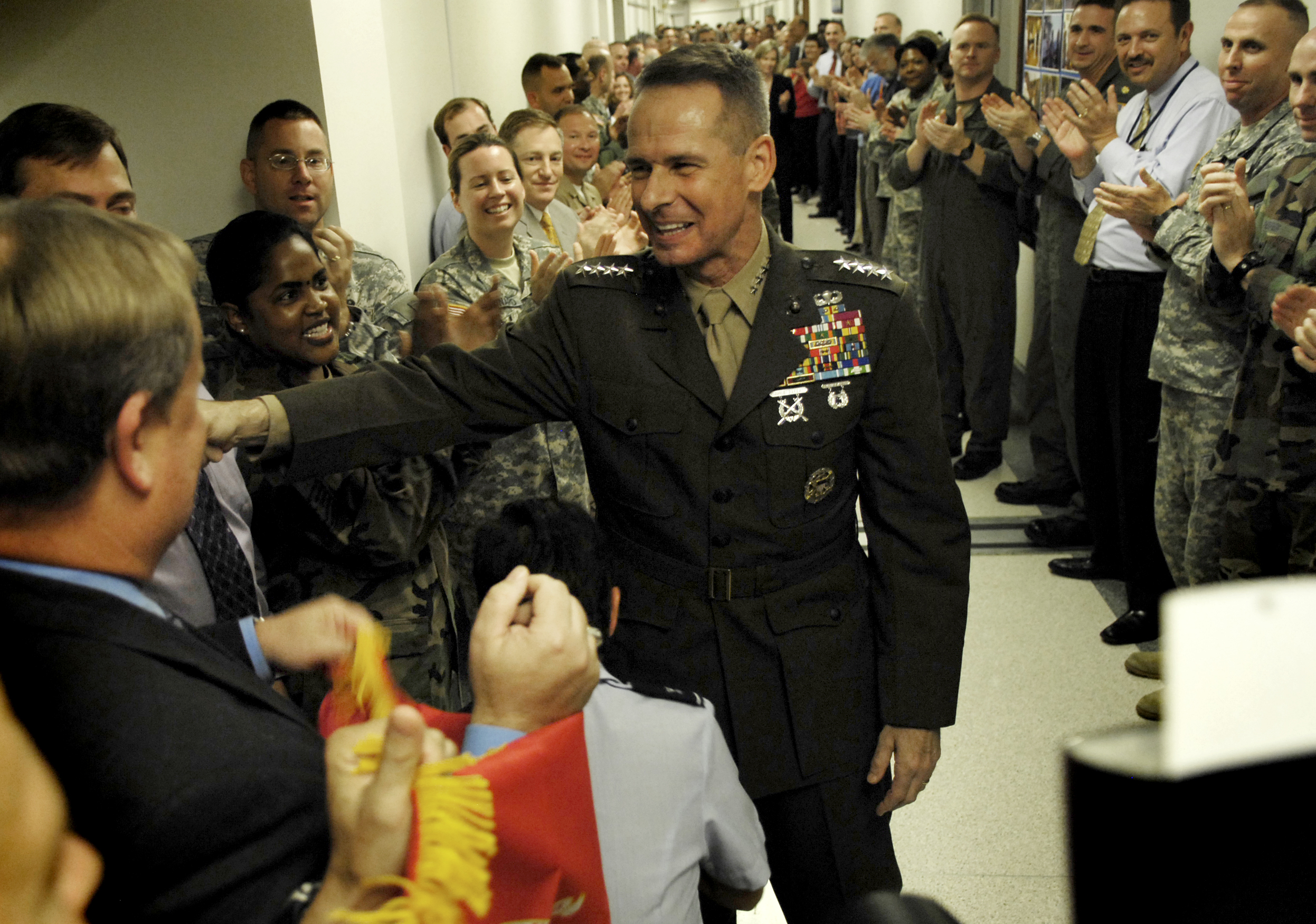 Men and women of the Defense Department line the halls and applaud ...