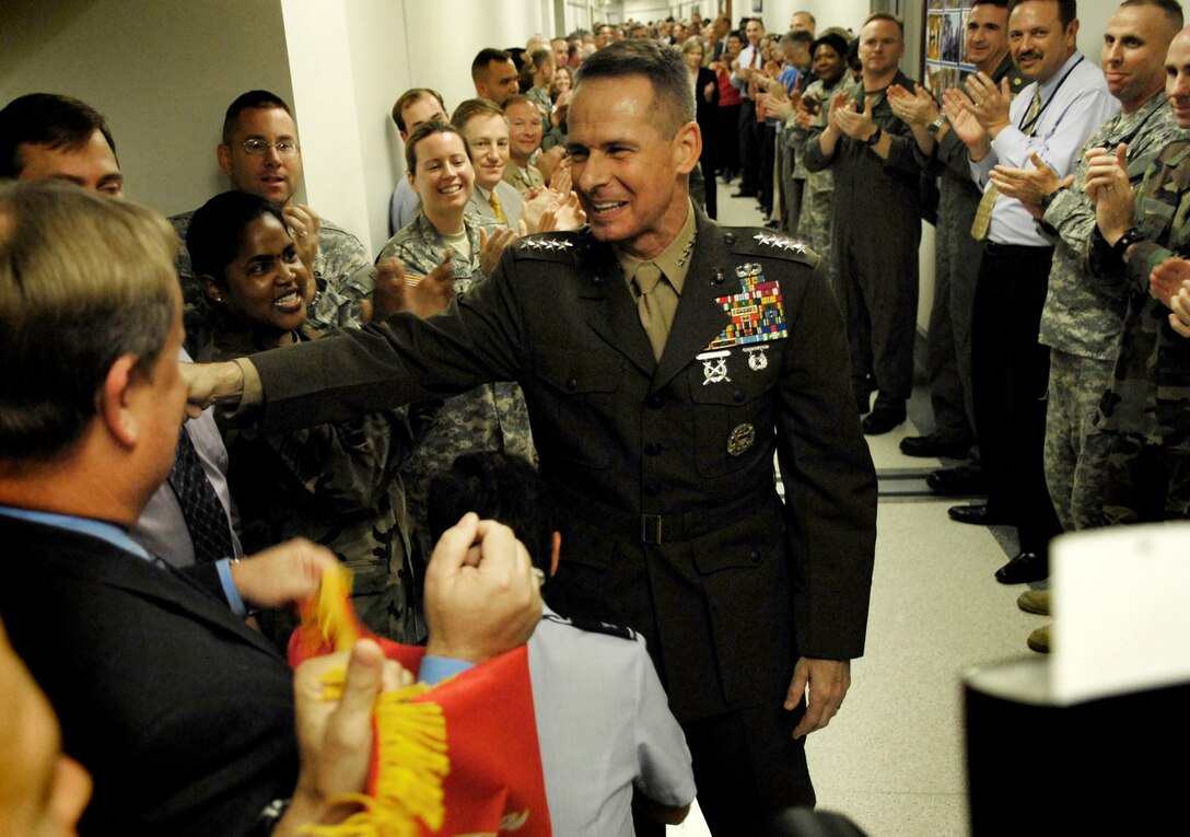 Men and women of the Defense Department line the halls and applaud ...