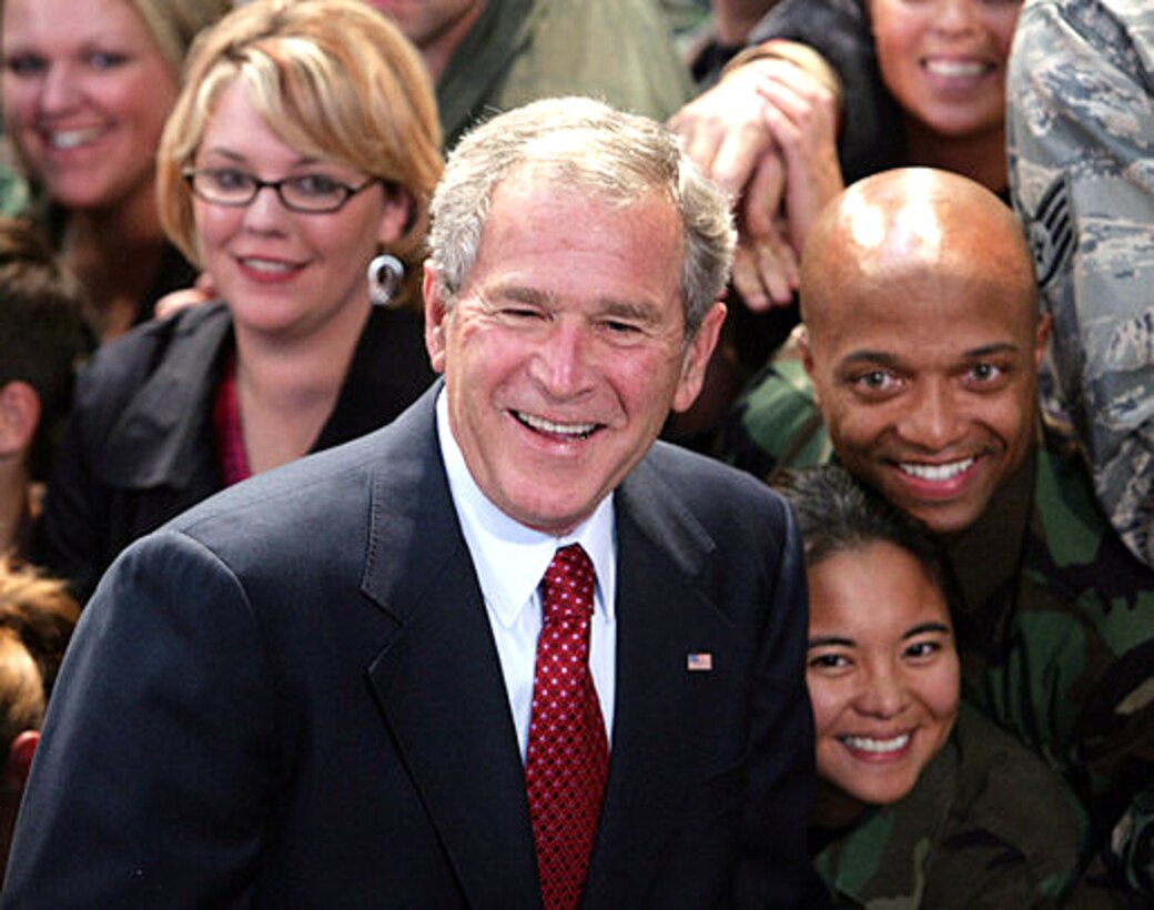 President George W. Bush poses for photos with members of the audience ...