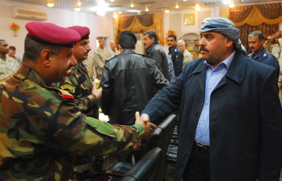 Mamoun Sami, right, governor of Iraq’s Anbar province, greets Iraq army ...