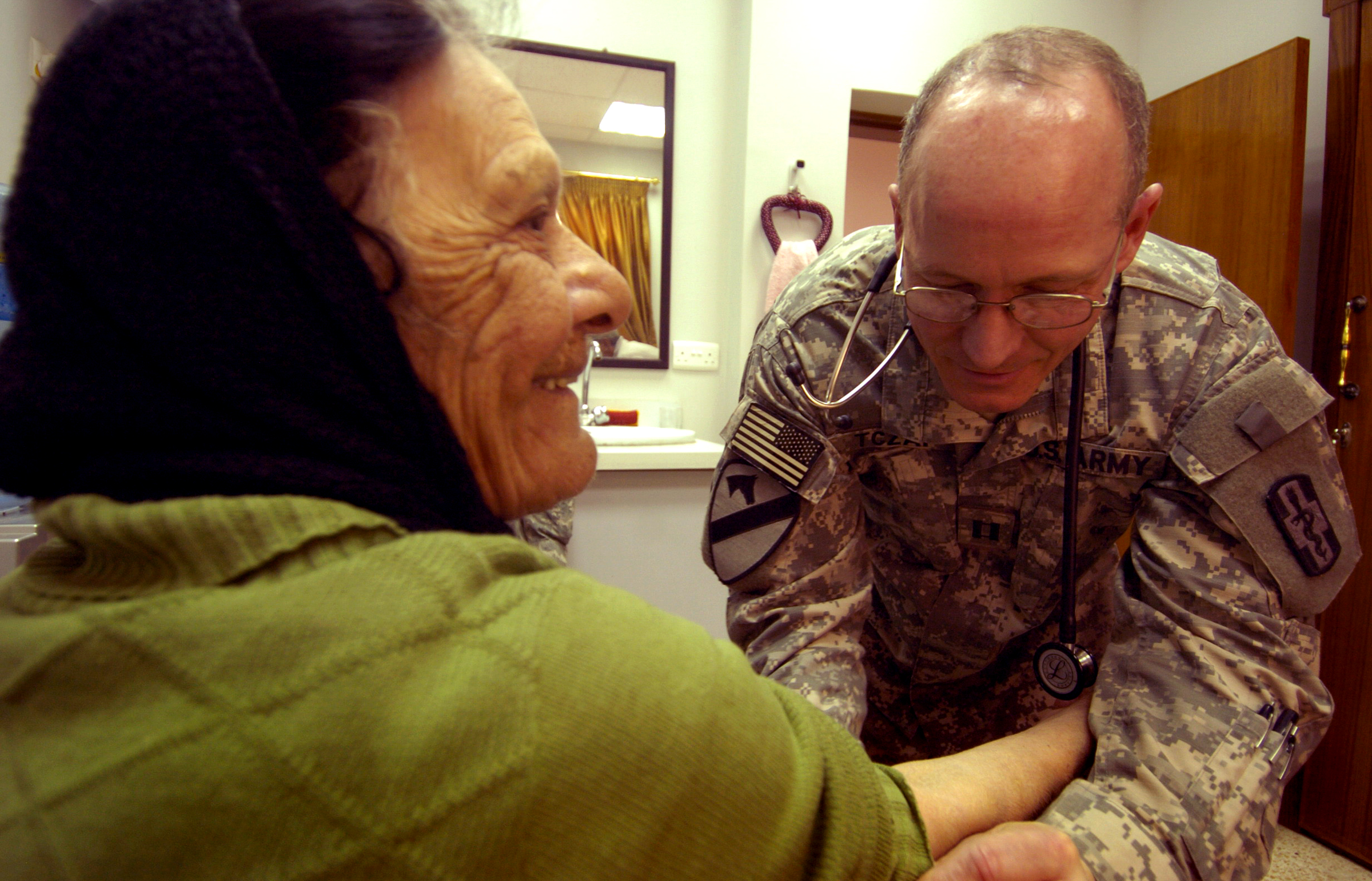 U.S. Army Capt. James Tczap examines an Iraqi woman during a combined ...