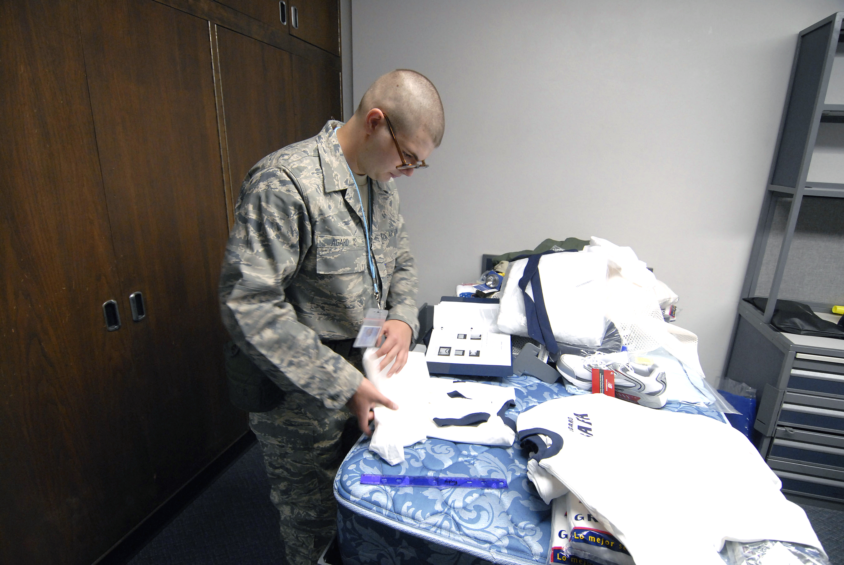Basic Cadet Troy Agard folds his physical training T-shirts after he is ...