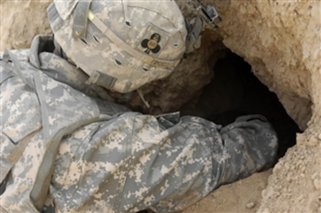 A U.S. Army soldier searches for weapons caches. | U.S. Department of War