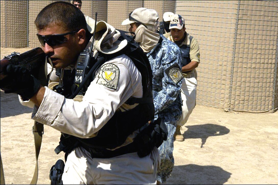 Iraqi Special Weapons and Tactics, or SWAT, police officers move ...