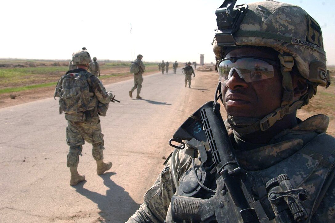 U.S. Army 1st Sgt. Eric Davis waits as his fellow soldiers move to ...