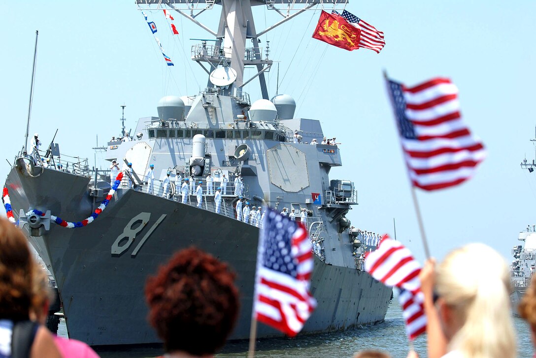 Families wave flags as the guided-missile cruiser USS Winston Churchill ...