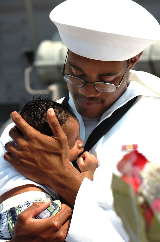U.S. Navy Seaman Calvin Ferguson holds his infant daughter during a ...