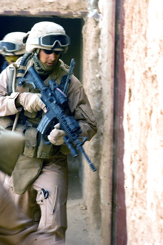 U.S. Marine Sgt. Daniel Leach clears a room while searching a house ...