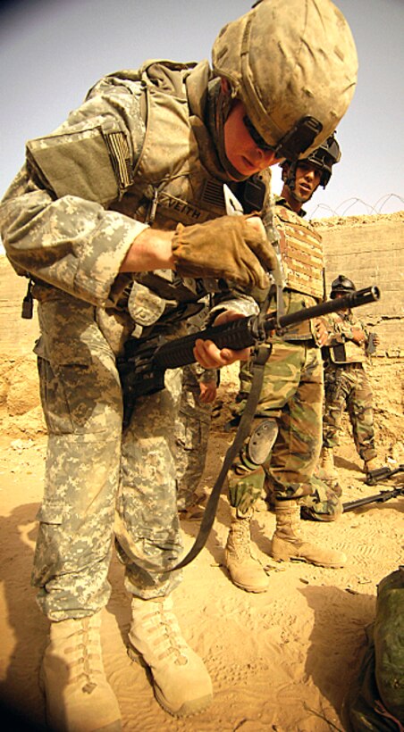 U.S. Army Sgt. Jake Veith calibrates an Iraqi army soldier's rifle ...