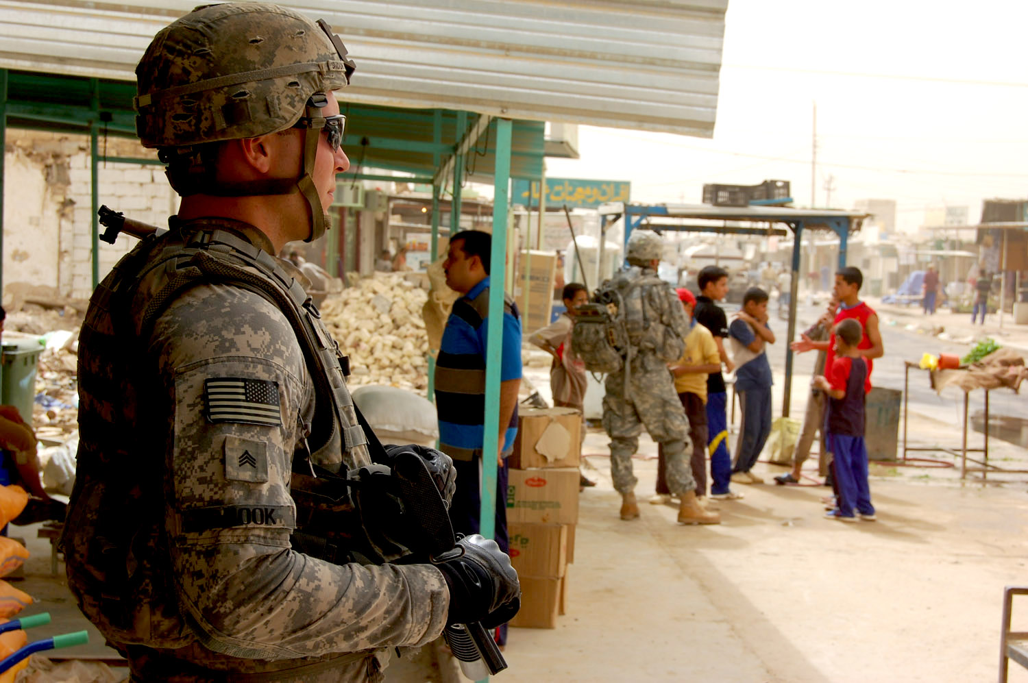 U.S. Army Sgt. Philip Snook pulls security in a busy marketplace in ...