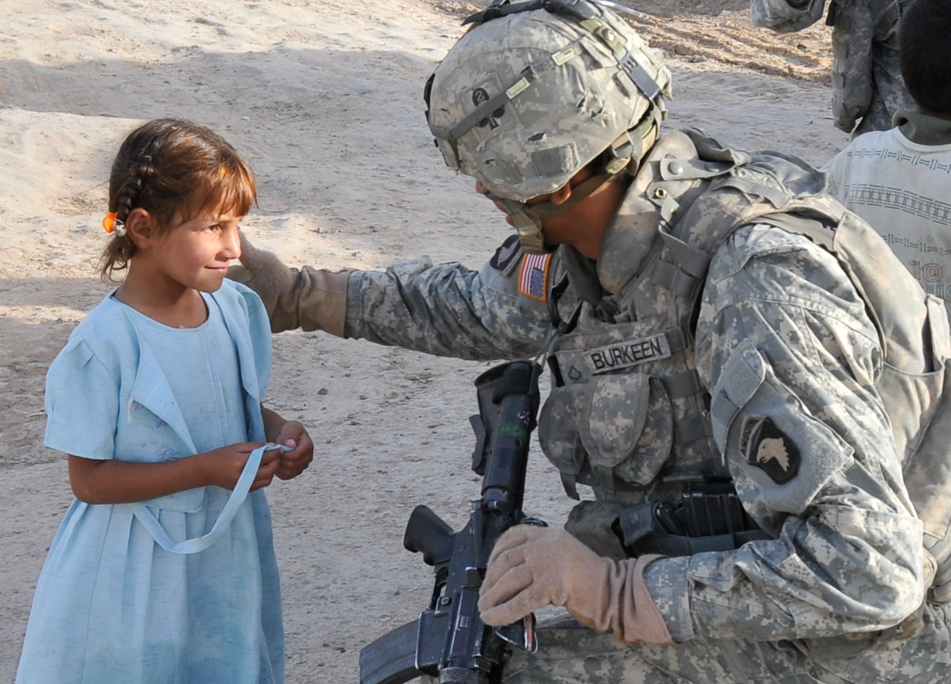 U.S. Army Pfc. Casey Burkheen chats with a young Iraqi girl during a ...