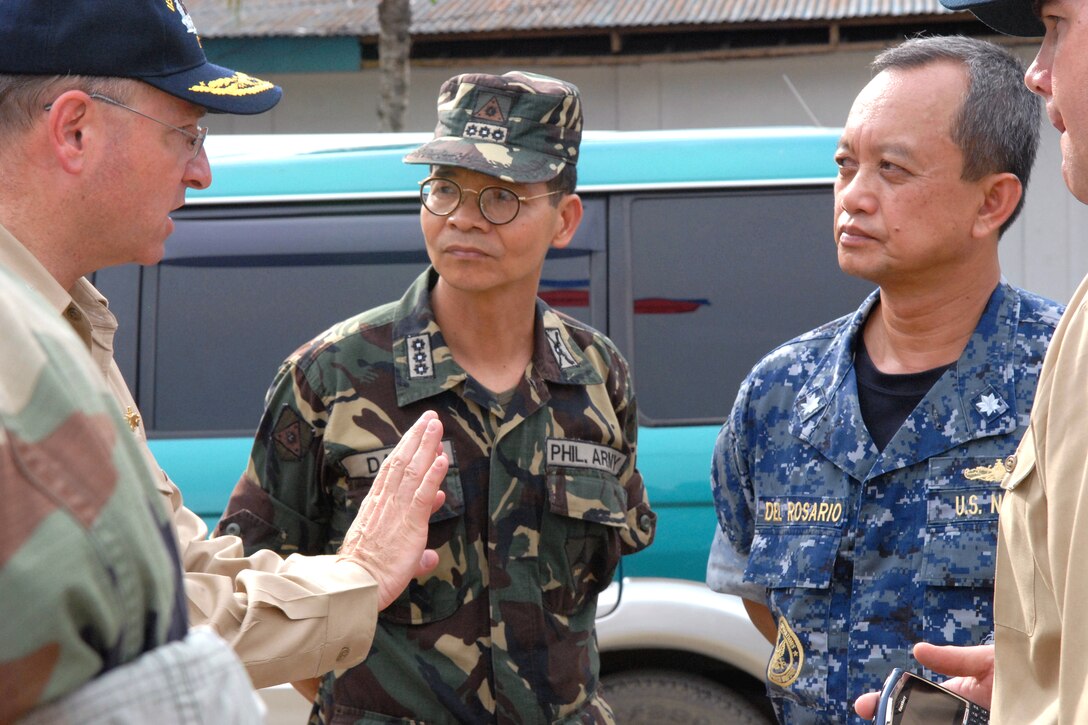 U.S. Navy Rear Adm. James P. Wisecup, left, speaks with Philippine Col ...