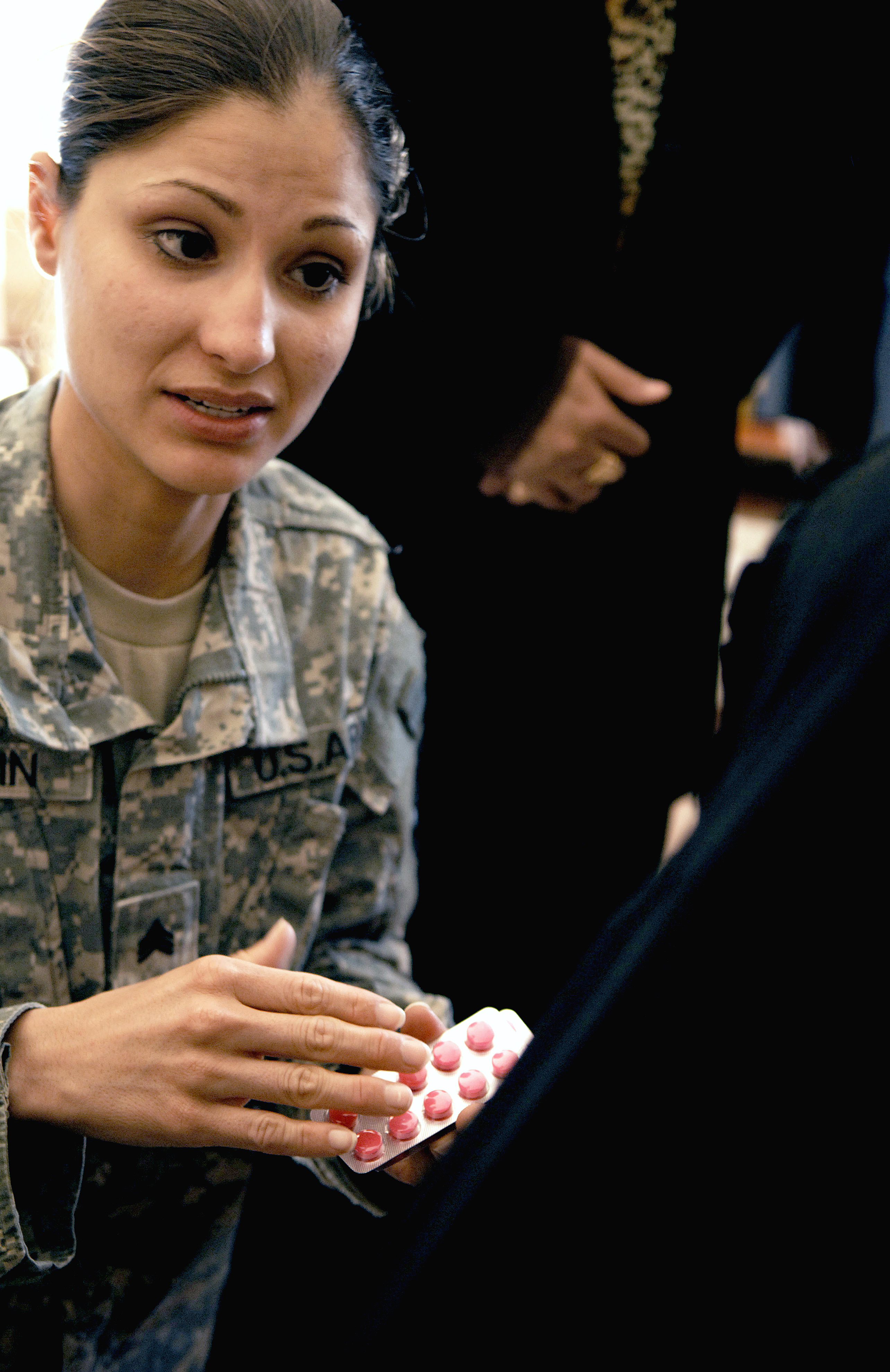 U.S. Army Sgt. Karina Colvin dispenses medication to a patient at a ...