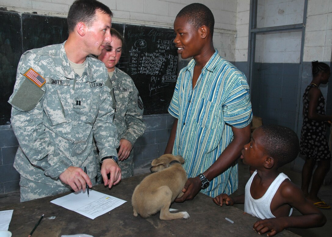 U.S. Army Capt. Brian Smith takes down information about a puppy ...