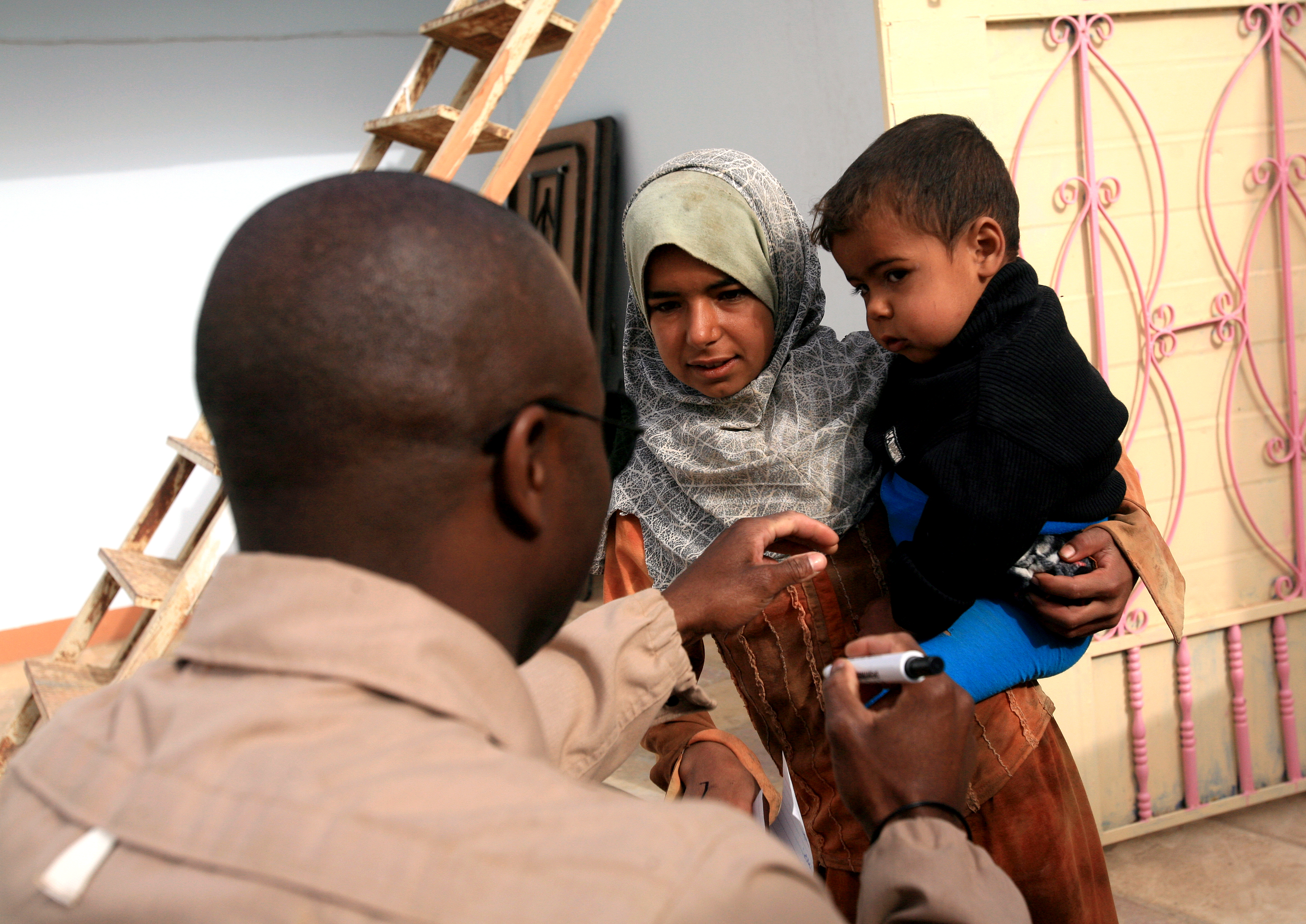 Carrying her brother, a confident Iraqi girl checks into the ...