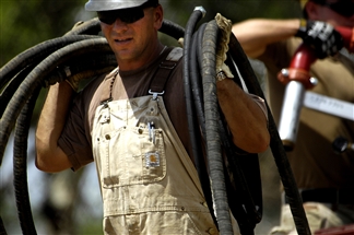 Petty Officer 1st Class Steven Barczak unloads hoses from a truck. | U ...