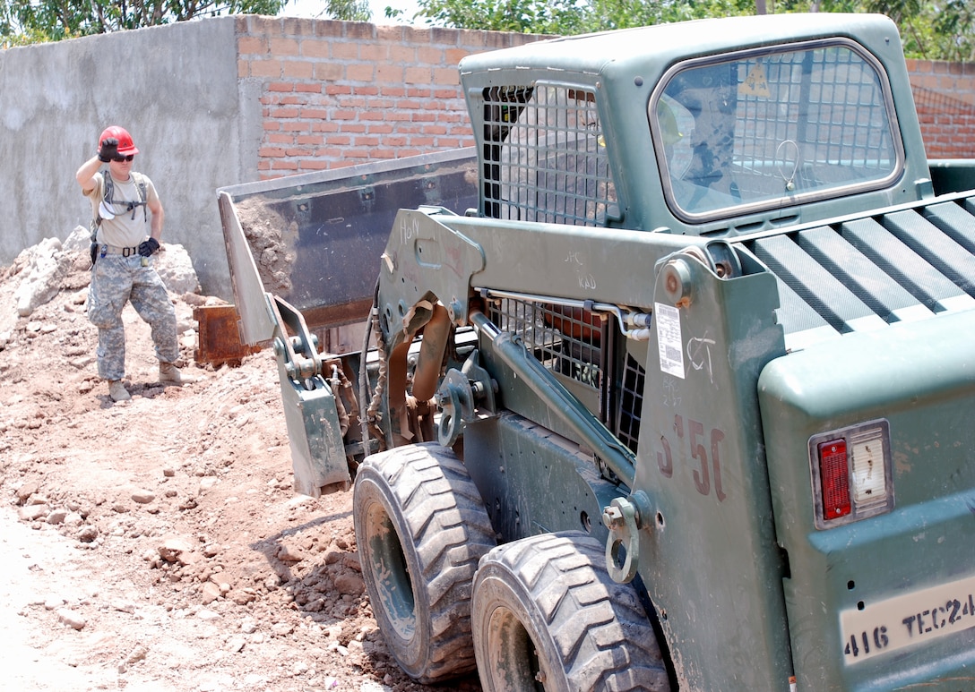 U.S. Army Staff Sgt. Timothy Phillips directs Spc. Kent Horstman ...